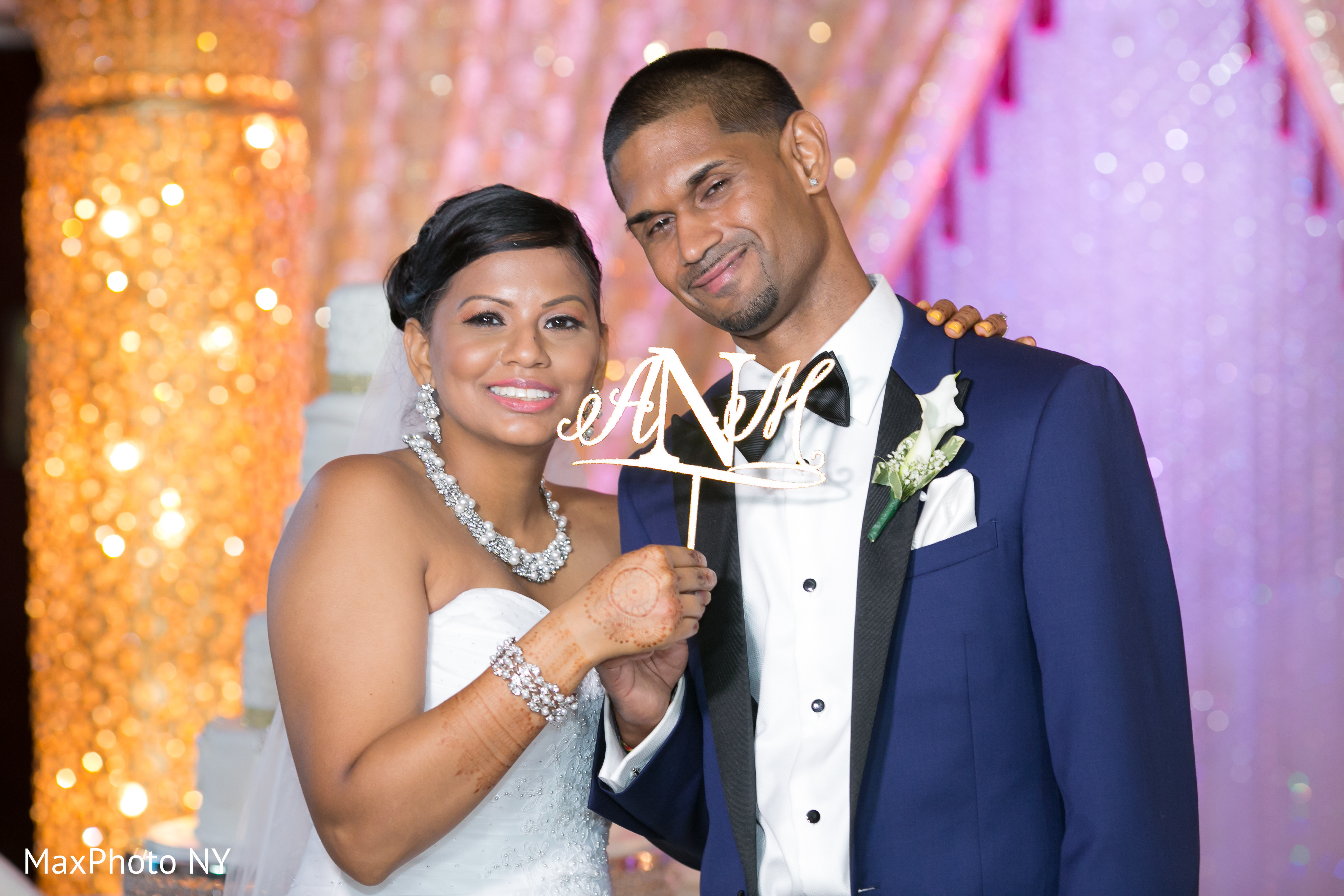 Happy couple posing with their customized cake topper. | Photo 101079