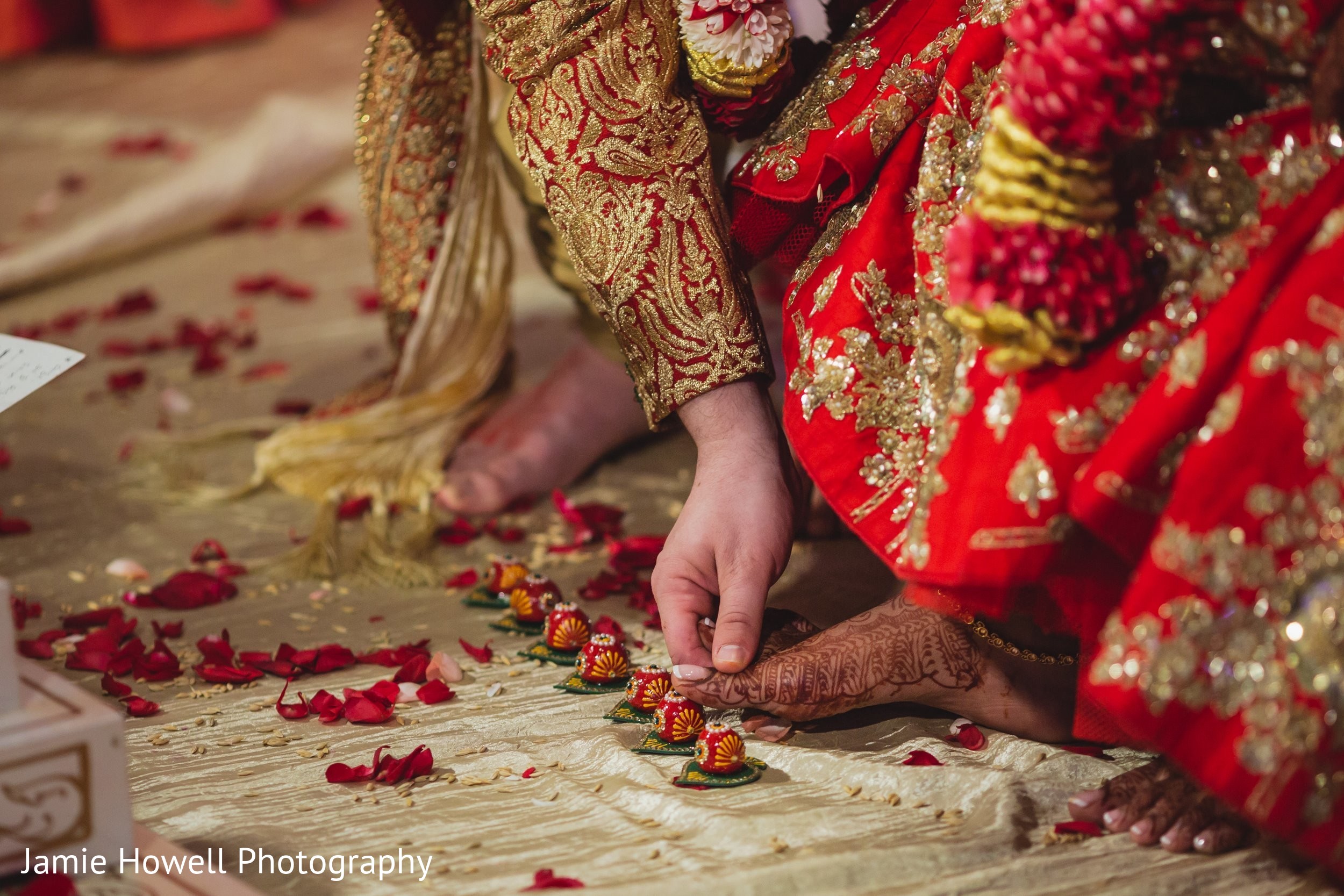 Indian bride and groom rolling betel nut with toes. | Photo 186118