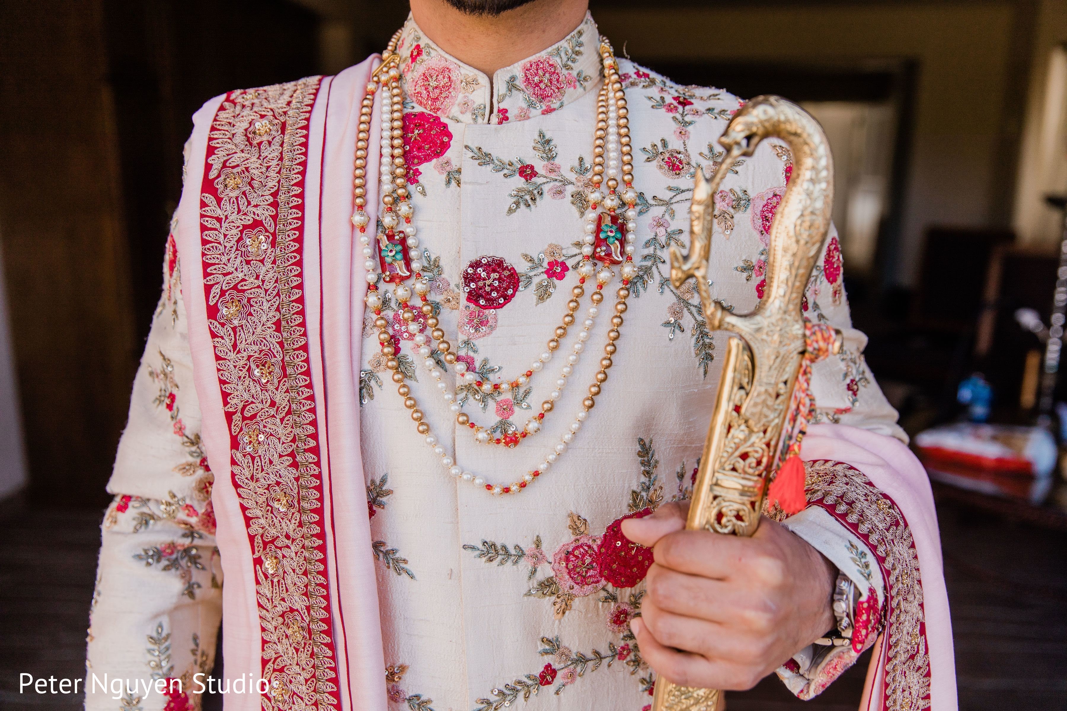 Closeup of Indian groom's sword, rani haar, dupatta and sherwani ...