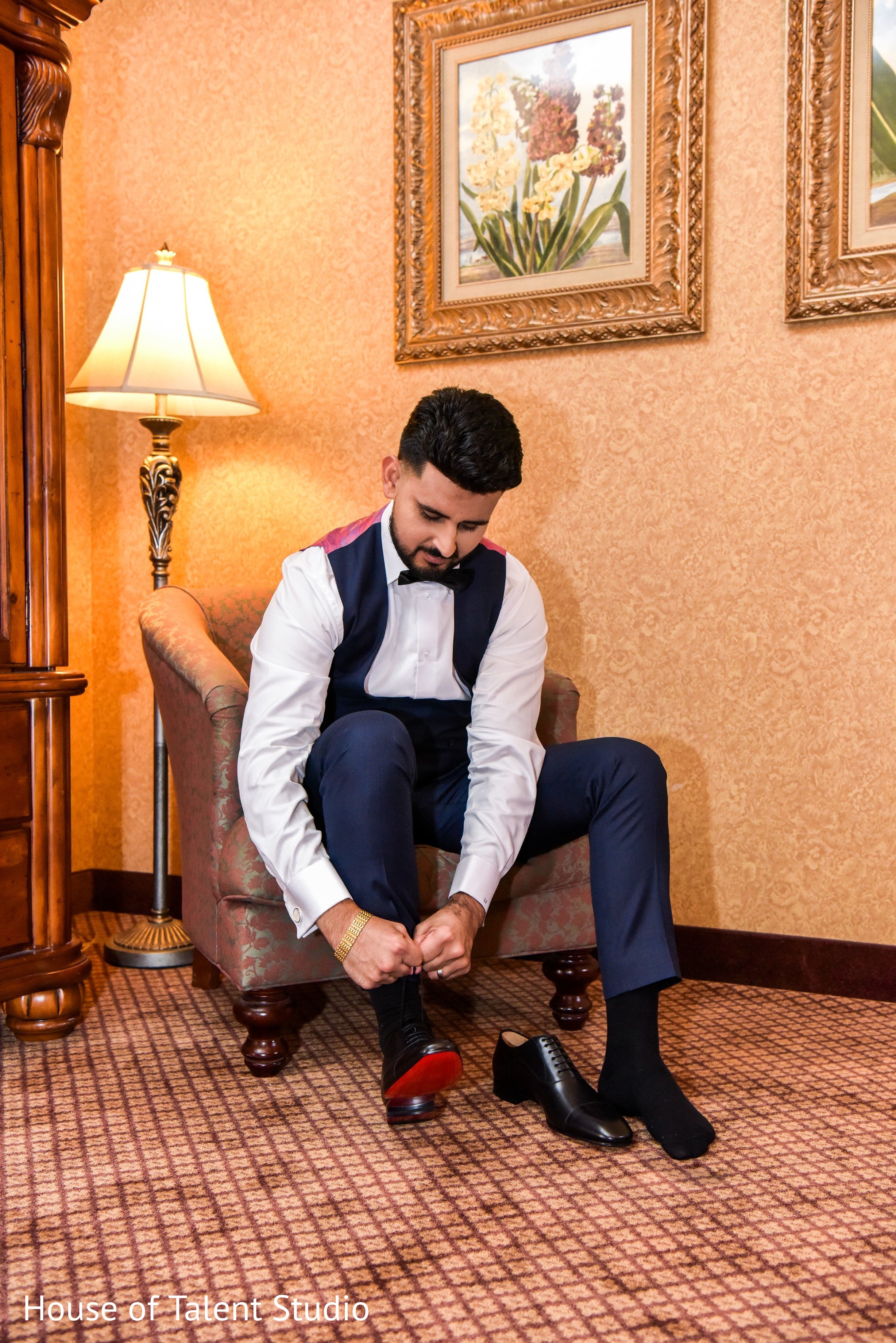Elegant Indian groom putting his reception shoes. | Photo 241556