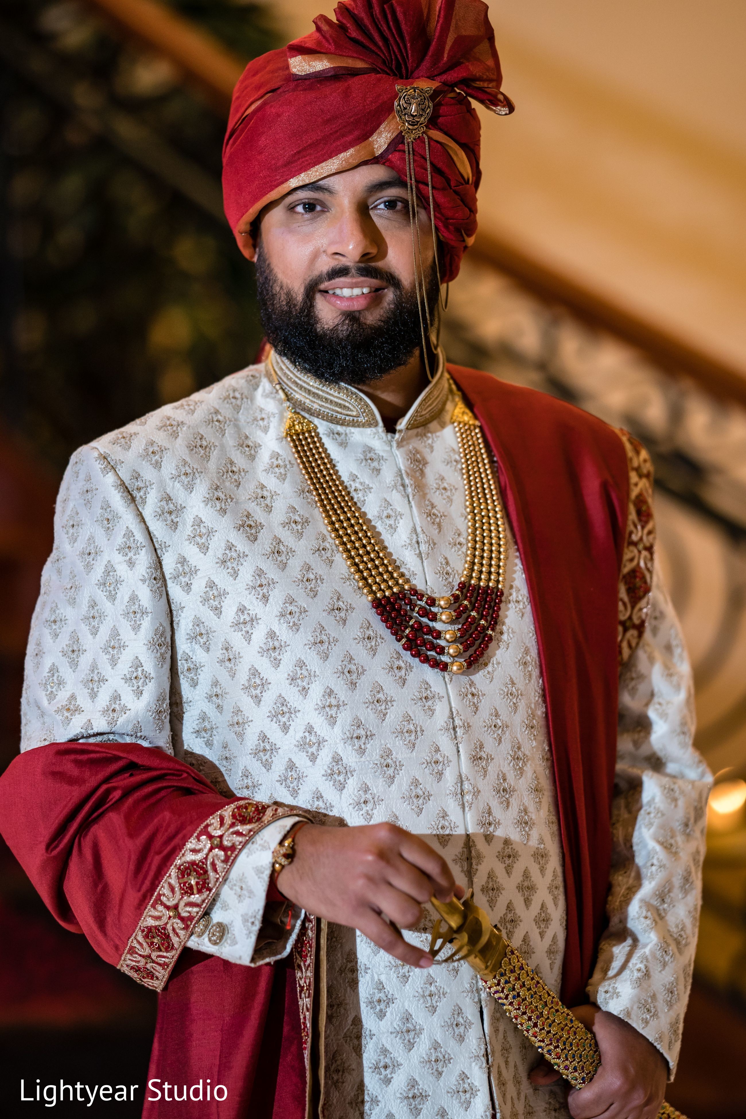 Raja posing for pictures wearing the white and silver sherwani. | Photo ...