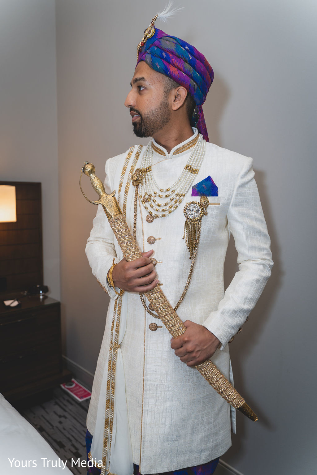 Indian groom in white posing with his wedding sword | Photo 263724